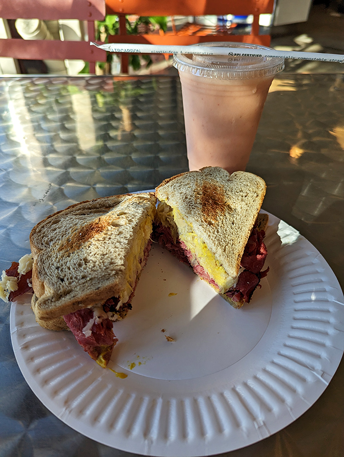 The Reuben, mid-bite&mdash;that magical moment when pastrami, melted cheese, and bread achieve perfect harmony on a paper plate.