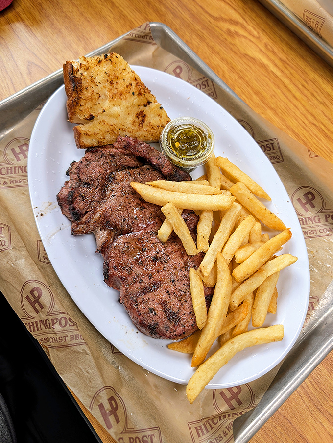 A perfectly grilled steak with crispy fries and garlic bread – the holy trinity of satisfaction that never goes out of style.