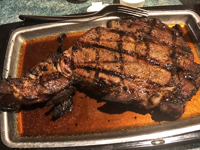 A ribeye so perfectly grilled it deserves its own ZIP code, basking in a pool of its own magnificent juices. 
