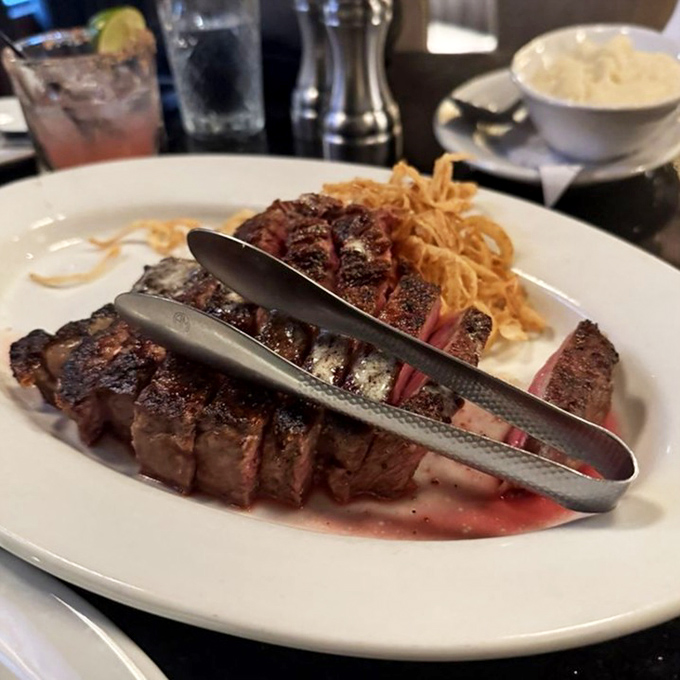 A ribeye sliced to reveal its perfect medium-rare interior &ndash; the kind of steak that makes conversation pause mid-sentence while everyone at the table stares in awe.