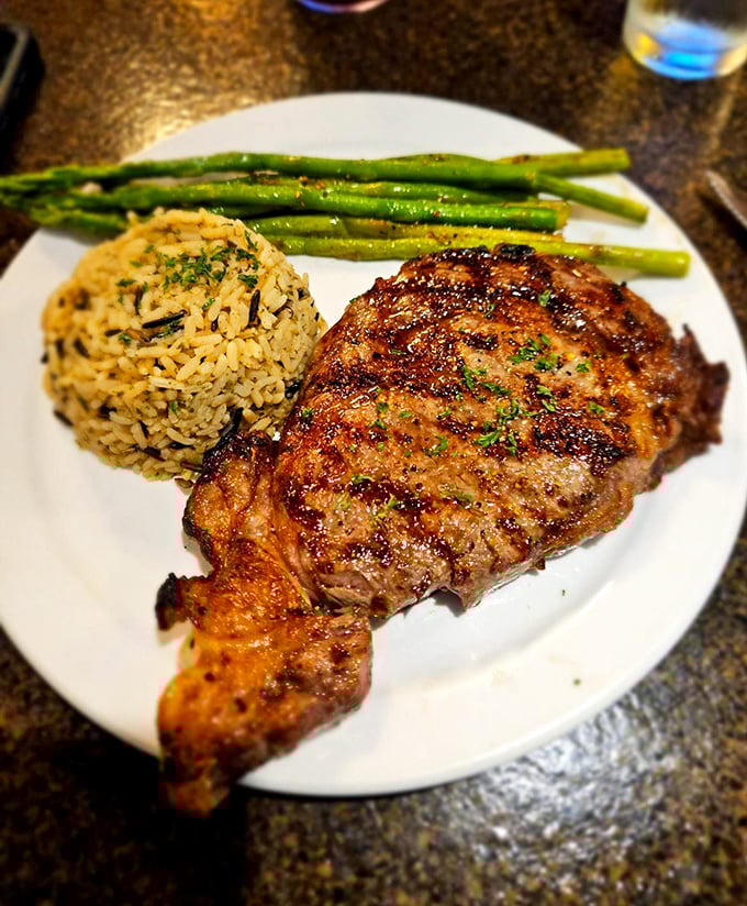 A perfectly grilled ribeye with rice pilaf and asparagus. Simple? Yes. Basic? Never. This is the difference between eating and dining.