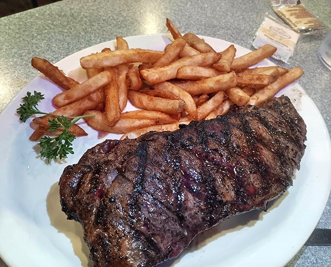 A perfectly grilled ribeye with a mountain of golden fries—proof that sometimes the simplest pleasures are the most satisfying.