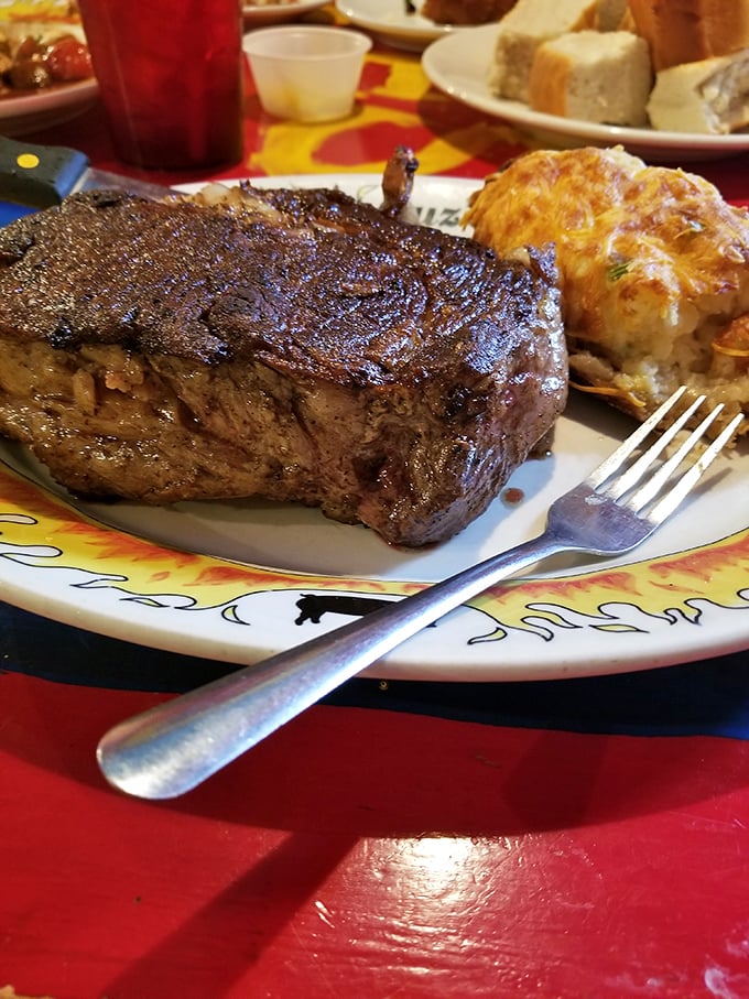 A ribeye so magnificent it deserves its own ZIP code, paired with what appears to be a twice-baked potato that's living its best life.