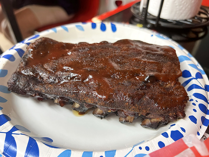 These ribs wear their sauce like a glossy coat of armor, protecting the tender, smoky meat beneath until you come along to claim it.