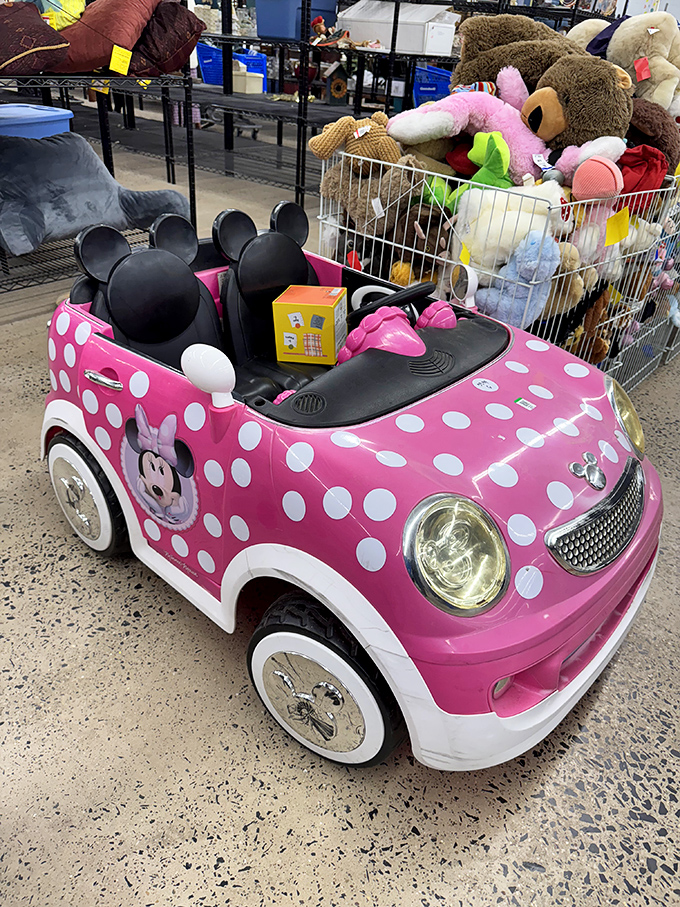 Childhood dreams at thrift store prices! This Minnie Mouse ride-on sits among stuffed animals, waiting for its second act in a lucky kid's playroom.