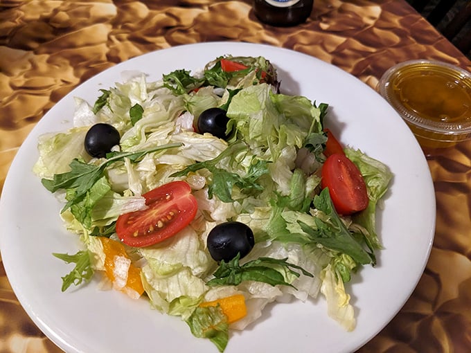 Even the salad gets special treatment &ndash; crisp lettuce, vibrant tomatoes, and olives that remind you vegetables deserve respect too, especially before pizza indulgence.