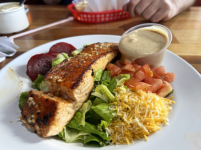 Perfectly grilled salmon perched atop fresh greens with all the fixings&mdash;proof that not everything delicious at a seafood joint needs a bath in the fryer.