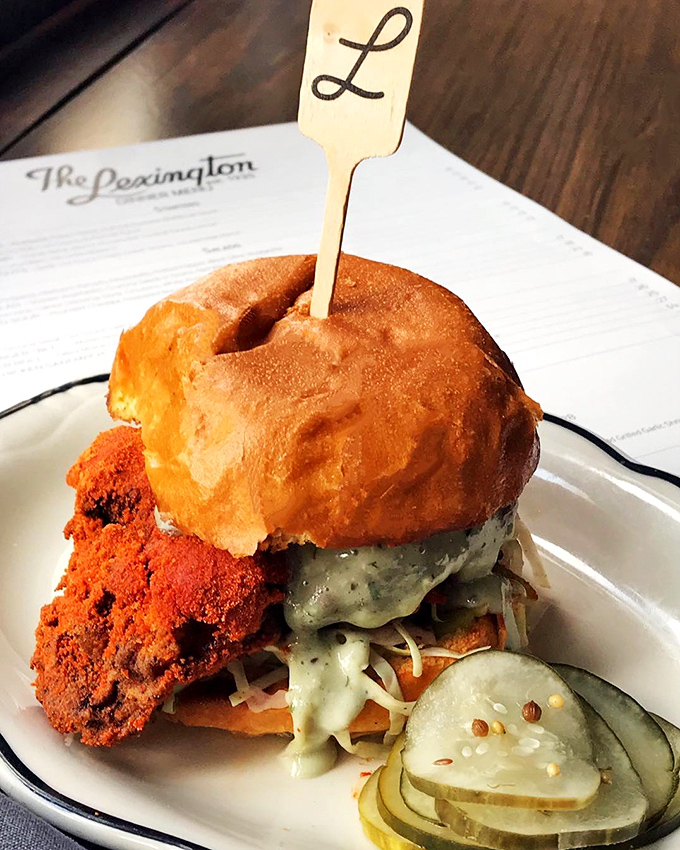 The Lexington's signature sandwich arrives proudly branded, a towering creation that demands both hands and your full attention.