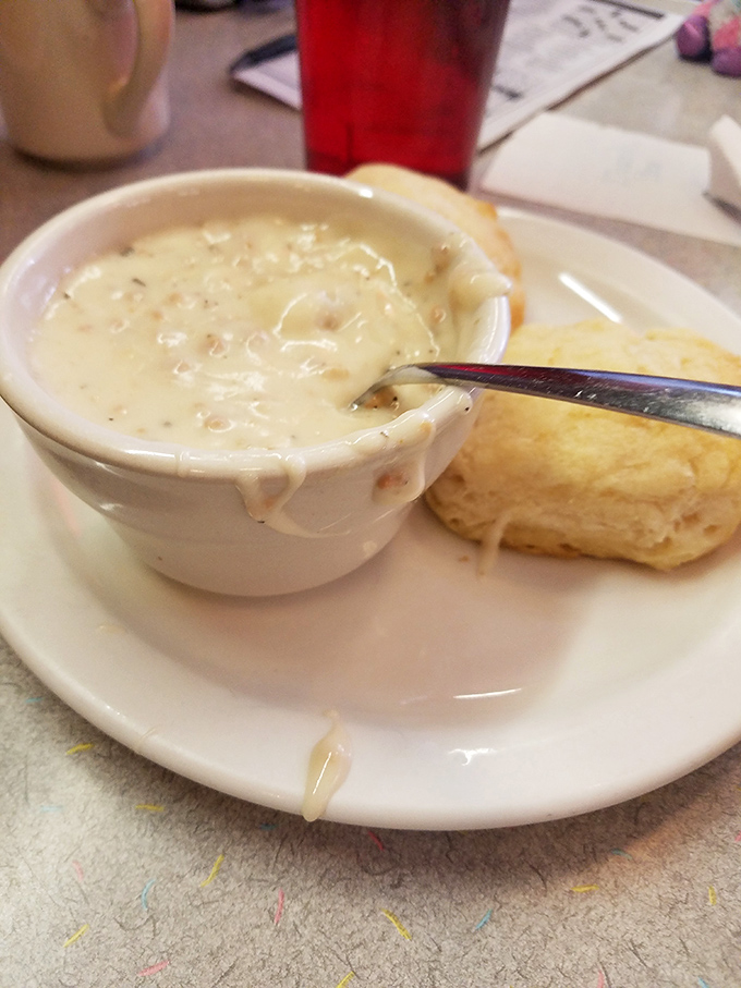 A bowl of creamy sausage gravy alongside a fresh-baked biscuit&mdash;the kind of breakfast that makes you want to hug the cook.