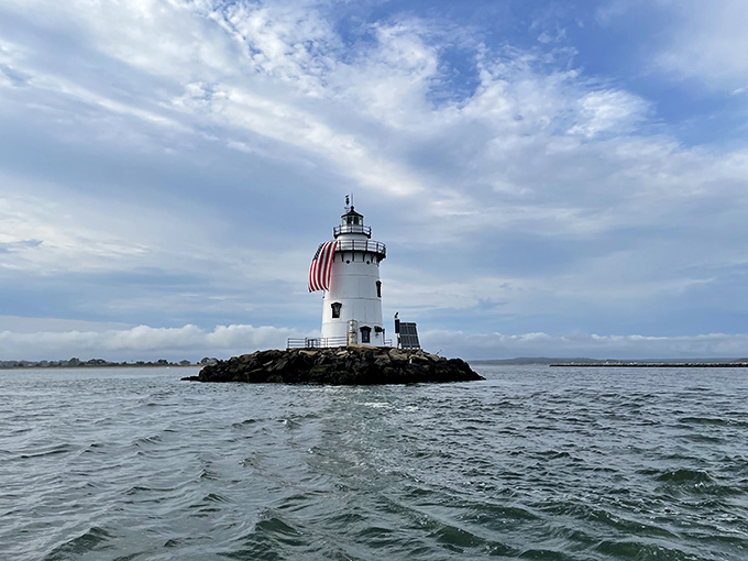 Saybrook Breakwater Lighthouse stands like a maritime exclamation point, proudly waving the stars and stripes while surrounded by its moat of possibility.
