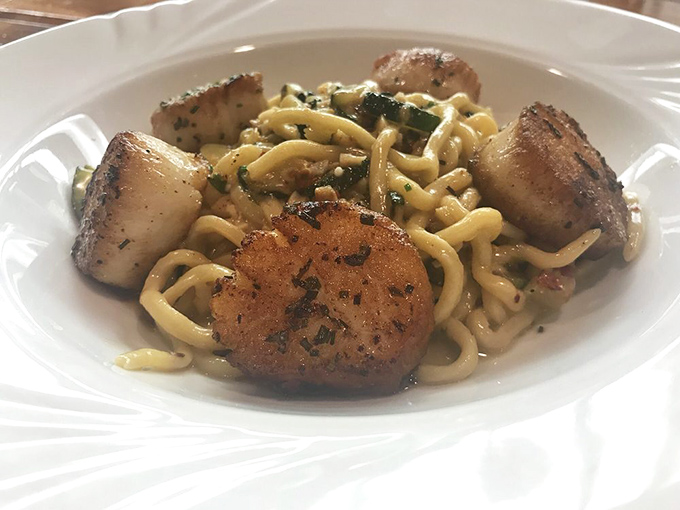 Perfectly seared scallops nestled in pasta prove that sometimes the specials menu is where the real magic happens.
