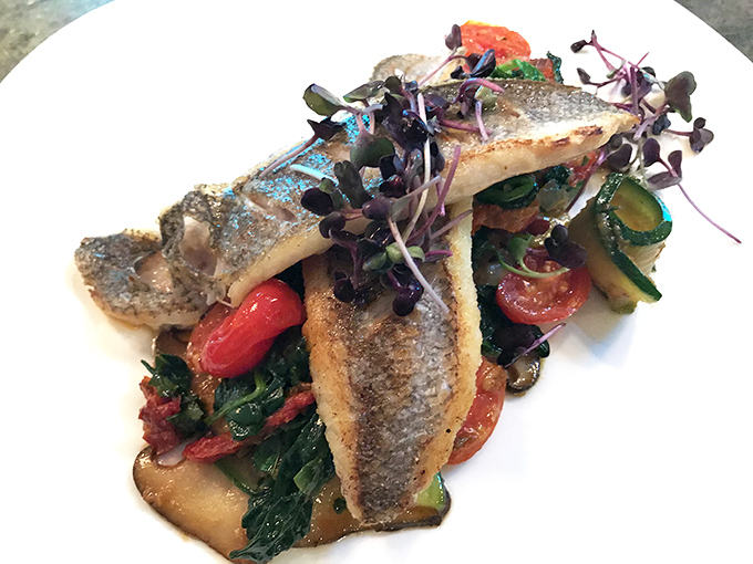 Sea bass that looks like it's posing for a magazine cover. Those vibrant vegetables aren't just supporting actors; they're stealing scenes in this culinary drama.