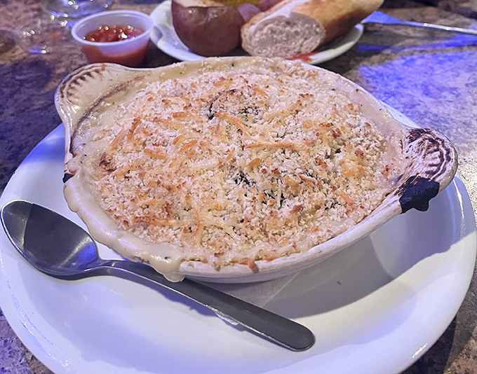 This bubbling seafood casserole arrives like a warm hug in ceramic form. That golden parmesan crust is hiding treasures from the deep.