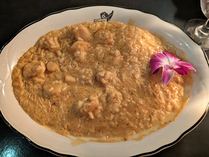 Seafood risotto that would make an Italian grandmother weep with joy, garnished with a vibrant orchid because beauty matters.