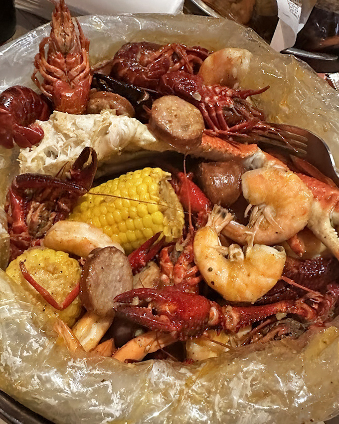This isn't just dinner; it's an edible treasure hunt. Crawfish, shrimp, and corn swimming in seasoned glory that demands hands-on exploration. 