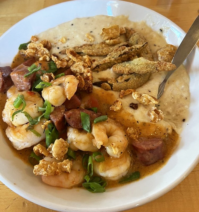 Southern hospitality on a plate &ndash; shrimp and grits elevated with andouille sausage and those crispy bits that make you close your eyes in bliss.