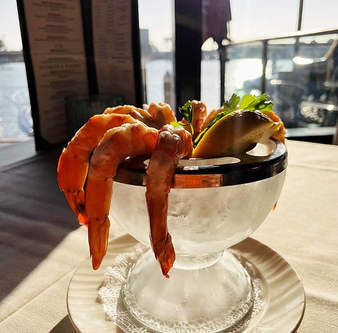 Jumbo shrimp draped over a cocktail glass like they're posing for their close-up, fresh and ready for their delicious debut.