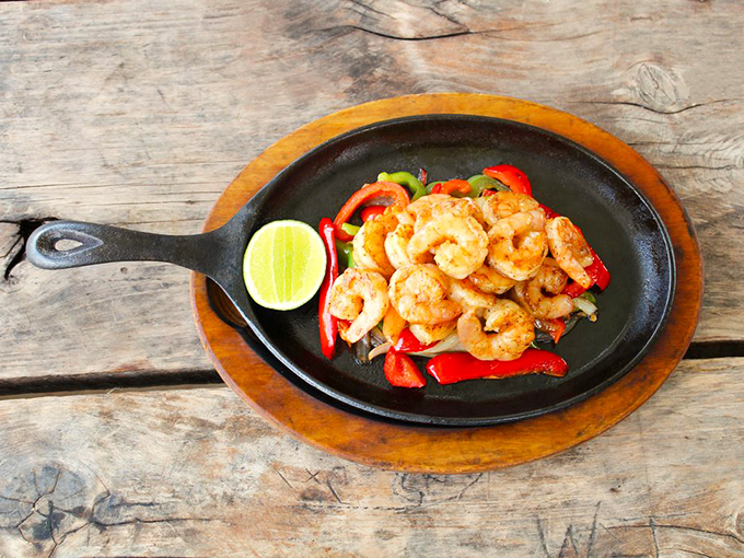 Sizzling shrimp fajitas arrive on a skillet hot enough to command attention from every table in the vicinity.