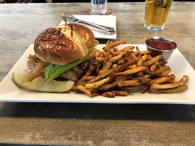 This isn't just a sandwich; it's architectural genius with crispy fries standing at attention, ready for their ketchup bath.
