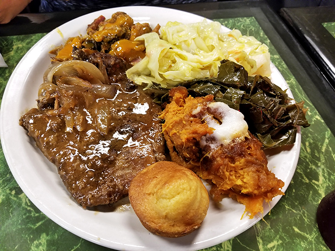 Soul food heaven on a plate: smothered pork chops, collard greens, sweet yams, and cornbread&mdash;a quartet that performs perfect harmony.