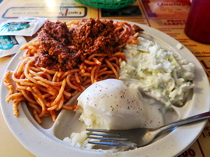 Spaghetti, mashed potatoes, and cole slaw share a plate in perfect harmony—a Midwestern symphony of comfort that feels like a warm hug.