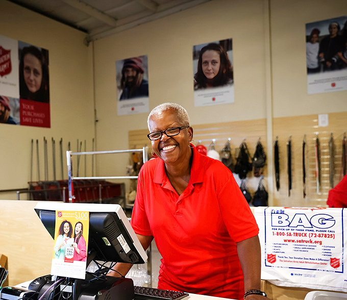 A smiling team member embodies the mission behind the merchandise&mdash;turning donations into dignity and community support with every transaction.