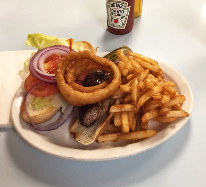 This isn't just a sandwich &ndash; it's architecture with flavor, where every layer from the crispy onion ring to the seasoned fries plays its part perfectly.