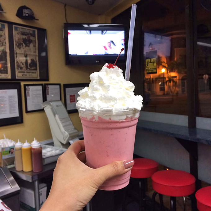 The strawberry milkshake towers with whipped cream like a pink skyscraper of sweetness&mdash;architecture you can sip through a straw.