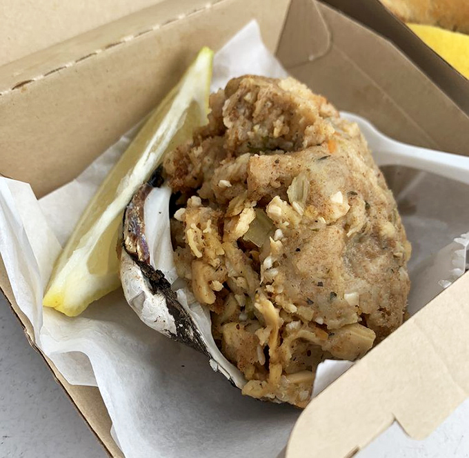 The stuffed clam sits like a savory treasure chest, packed with seasoned breadcrumbs and briny bits of the sea.