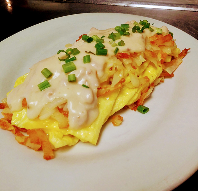 This omelet masterpiece topped with country gravy and nestled beside crispy hash browns proves that breakfast is indeed the most important meal.