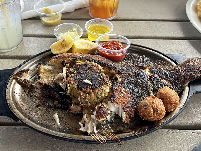 The stuffed flounder arrives like seafood royalty on its throne, flanked by hushpuppy courtiers and lemon wedge attendants.