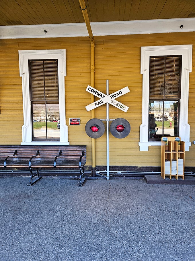 Simple wooden benches and a railroad crossing sign—sometimes the most memorable souvenirs are the moments of anticipation before the journey begins.