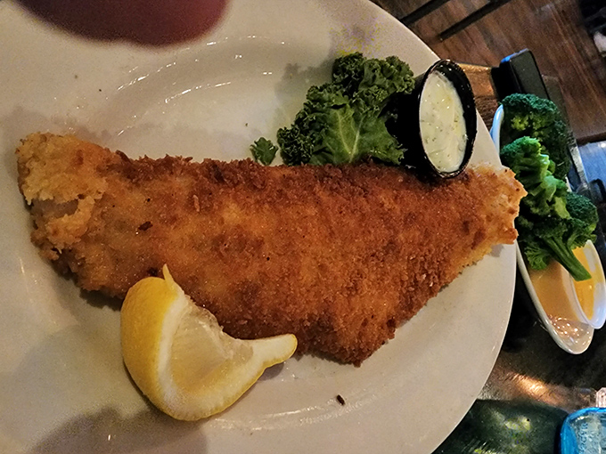 The walleye arrives golden and crisp, a Midwestern delicacy treated with the respect it deserves, accompanied by bright lemon and verdant broccoli.