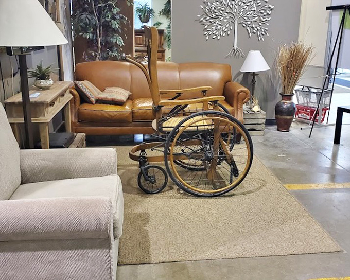 Vintage meets function in this display featuring a beautifully preserved leather sofa and an antique wheelchair that could star in a period film.