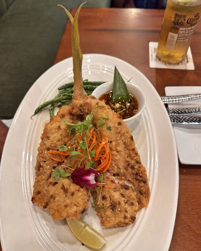 Crispy yellowtail presented with artistic flair and a side of green beans. The edible orchid isn't just pretty&mdash;it's a promise of excellence.