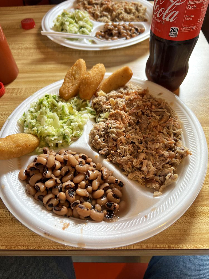 A proper North Carolina barbecue plate where pork, slaw, and hush puppies live in delicious harmony like old friends.