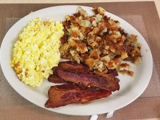 A breakfast trinity that would make any morning holy: fluffy scrambled eggs, perfectly crisped bacon, and those home fries that deserve their own Pennsylvania historical marker.