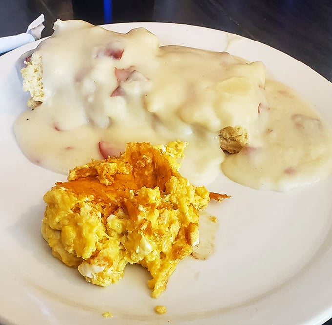 Biscuits swimming in creamy gravy alongside scrambled eggs that look like clouds of breakfast joy. This plate is why elastic waistbands were invented.