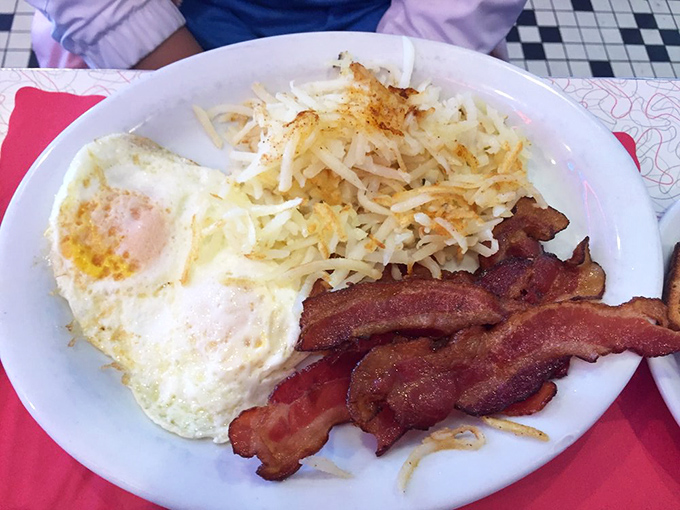 The breakfast trinity: perfectly crispy hash browns, eggs with sunset-yellow yolks, and bacon that makes a compelling argument against vegetarianism.