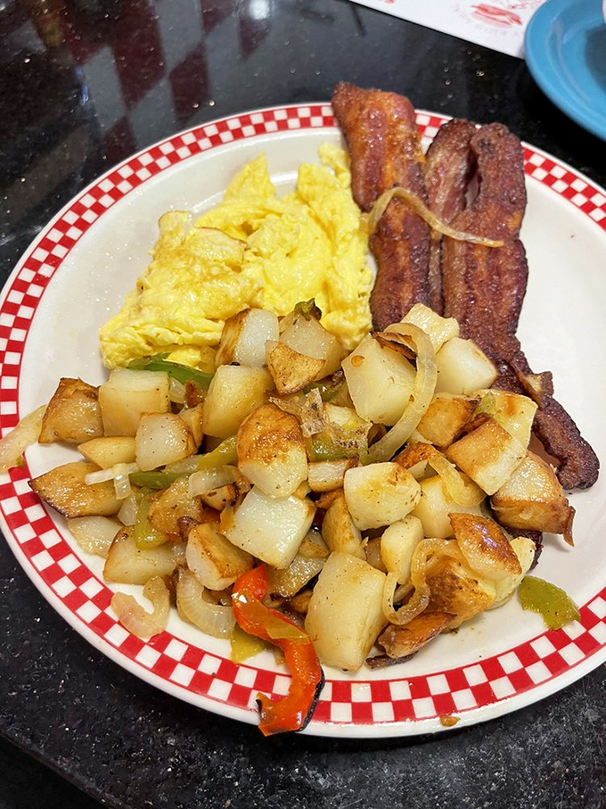 The breakfast trinity: perfectly scrambled eggs, home fries with personality, and bacon cooked exactly how you requested. Morning salvation on a plate.