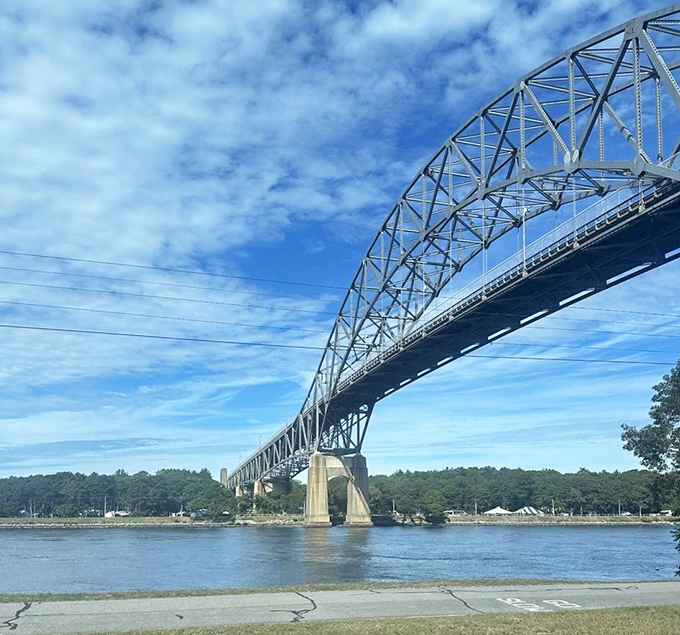 The Cape Cod Canal Railroad Bridge stretches majestically across blue waters. From the train, passengers glimpse this engineering marvel from angles car-bound tourists will never experience.