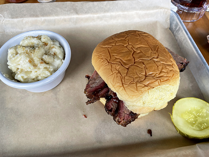Simplicity perfected: a pillowy bun cradling slices of brisket with a pickle standing guard. Sometimes the best things need no elaboration.