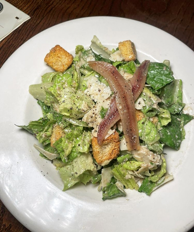Caesar salad topped with anchovies and croutons, proving that sometimes the classics become classics for very good, delicious reasons.