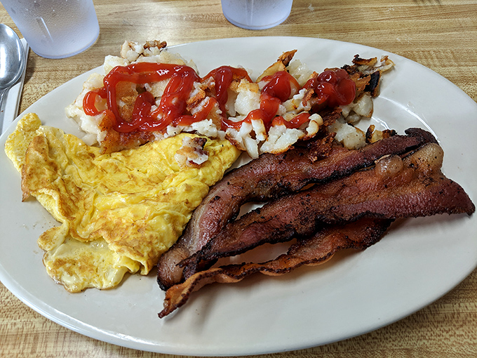 The breakfast trinity: golden eggs, bacon cooked to that perfect point between chewy and crisp, and potatoes that deserve their own fan club.