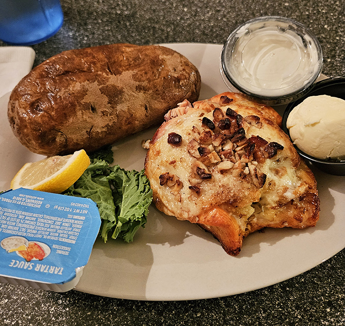 This crab-stuffed salmon wears its bacon crown with dignified pride, while the baked potato stands by like a loyal, butter-drenched sidekick.