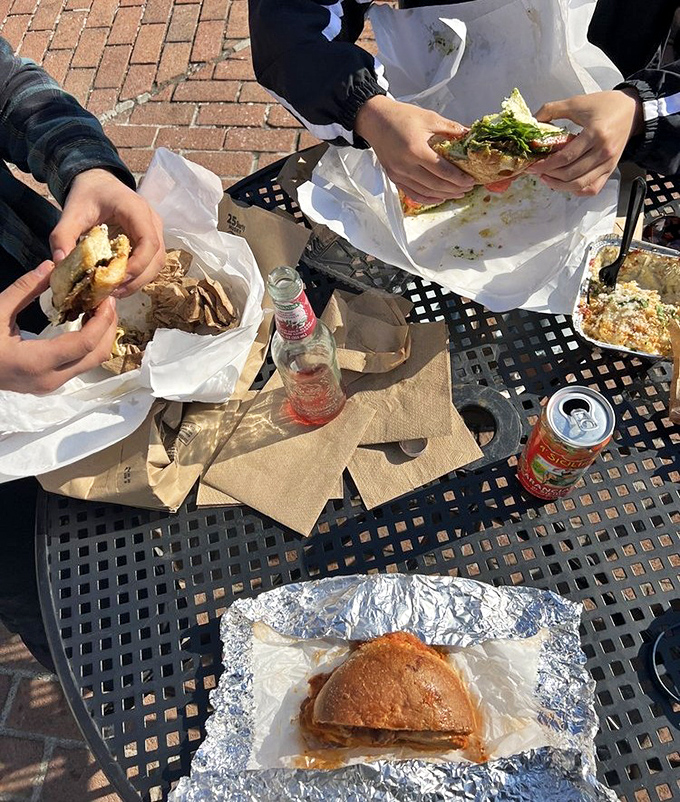 Nothing says "lunch done right" quite like friends, sunshine, and sandwiches that require both hands and a strategy.
