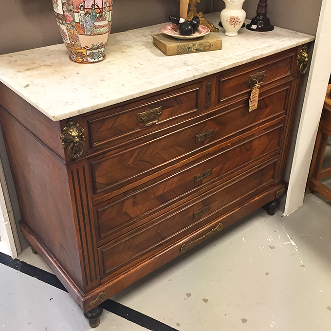 This marble-topped dresser with intricate woodwork isn't just furniture&mdash;it's functional architecture that's survived longer than most relationships.