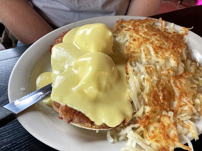 Benedict perfection: two golden orbs perched atop their English muffin thrones, crowned with hollandaise that cascades like morning sunshine.