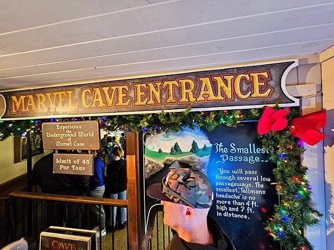 "Experience Underground World"&mdash;the cave entrance sign promises adventure while warning tall folks about the "headache" of low passages ahead.