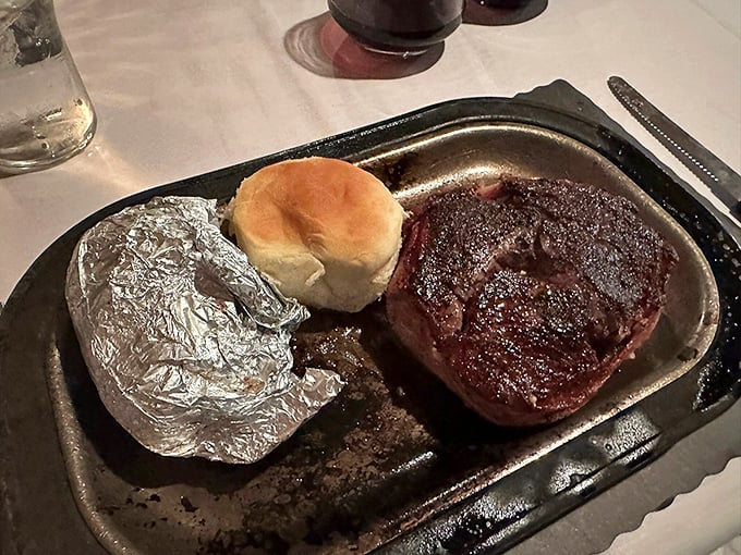 The filet mignon sits regally on its metal throne, tender enough to cut with a stern look, accompanied by au jus for dunking.